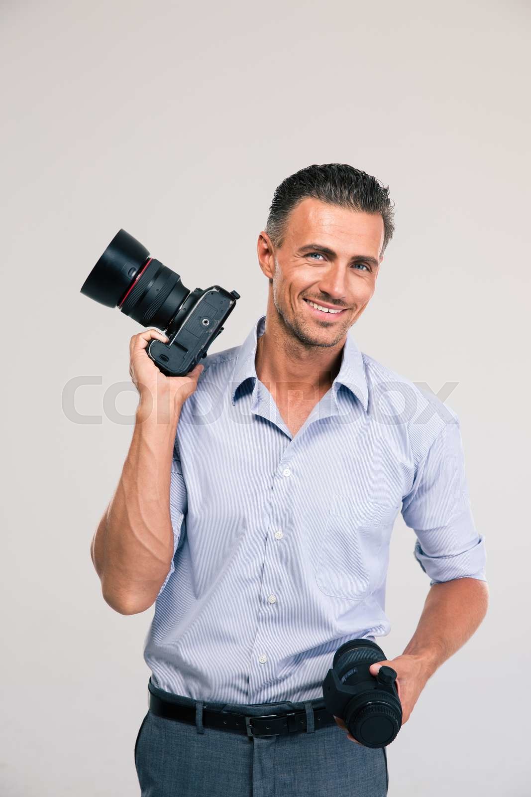 Handsome photographer holding camera | Stock image | Colourbox
