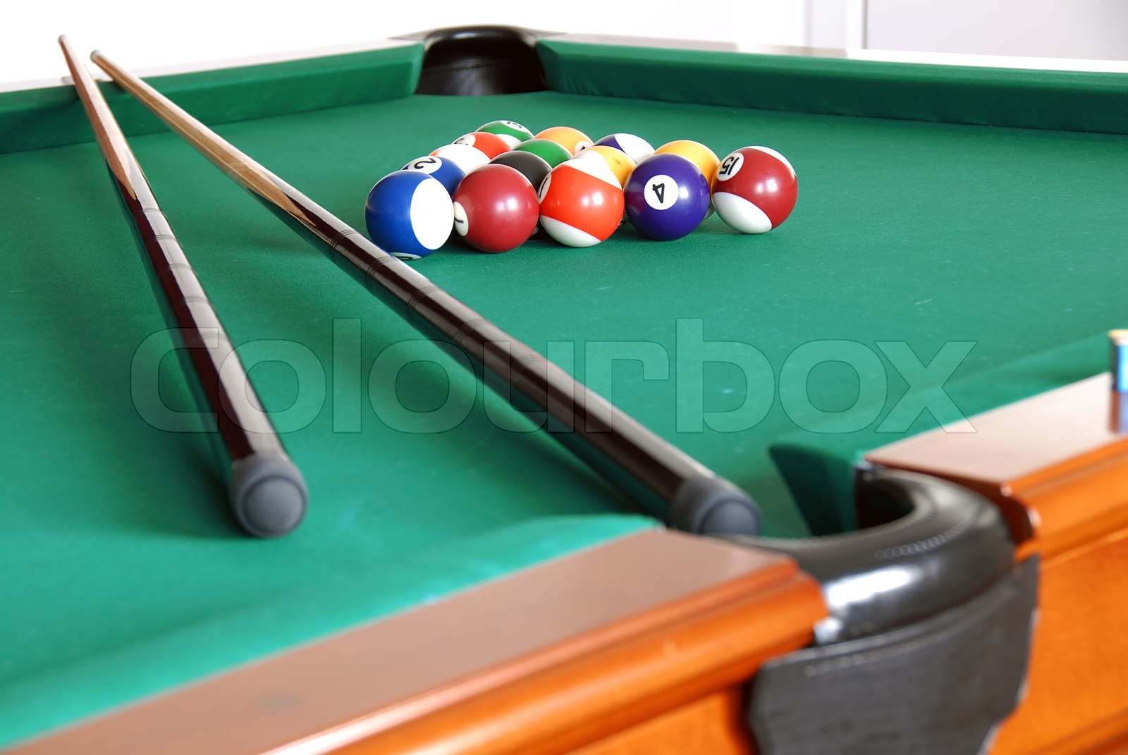 billard grønne bord med kugler og to sorte cues | Stock foto | Colourbox