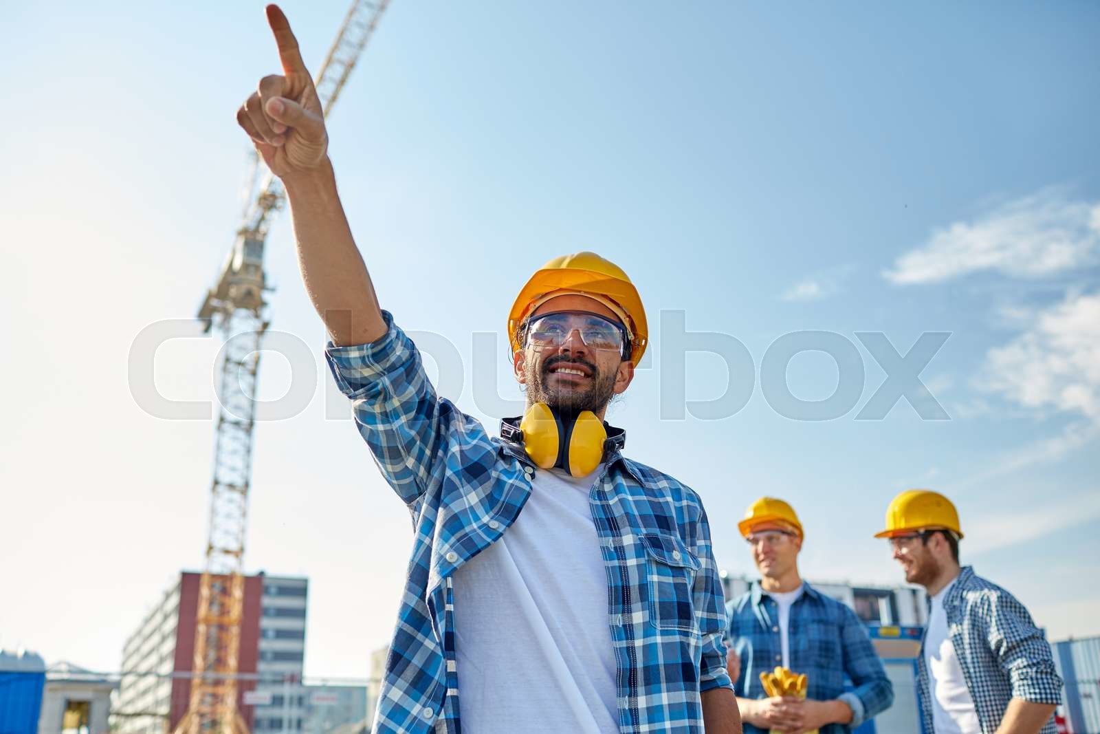 builders pointing finger aside on construction | Stock image | Colourbox
