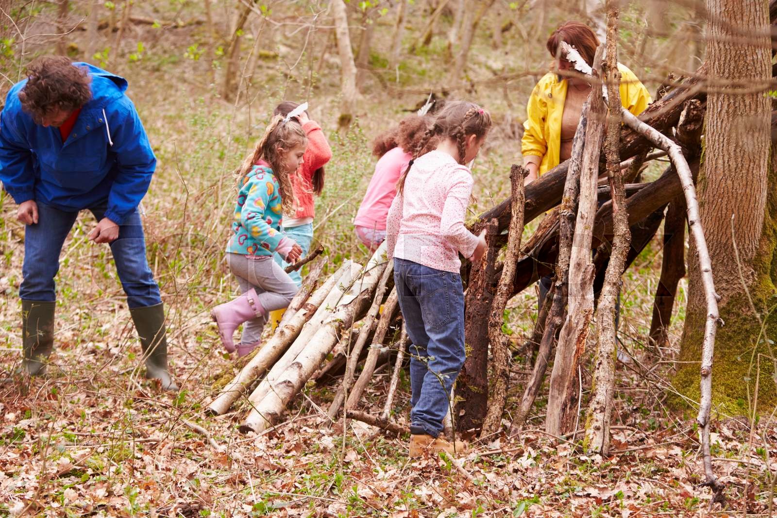 Adults And Children Building Camp At Outdoor Activity Centre | Stock ...
