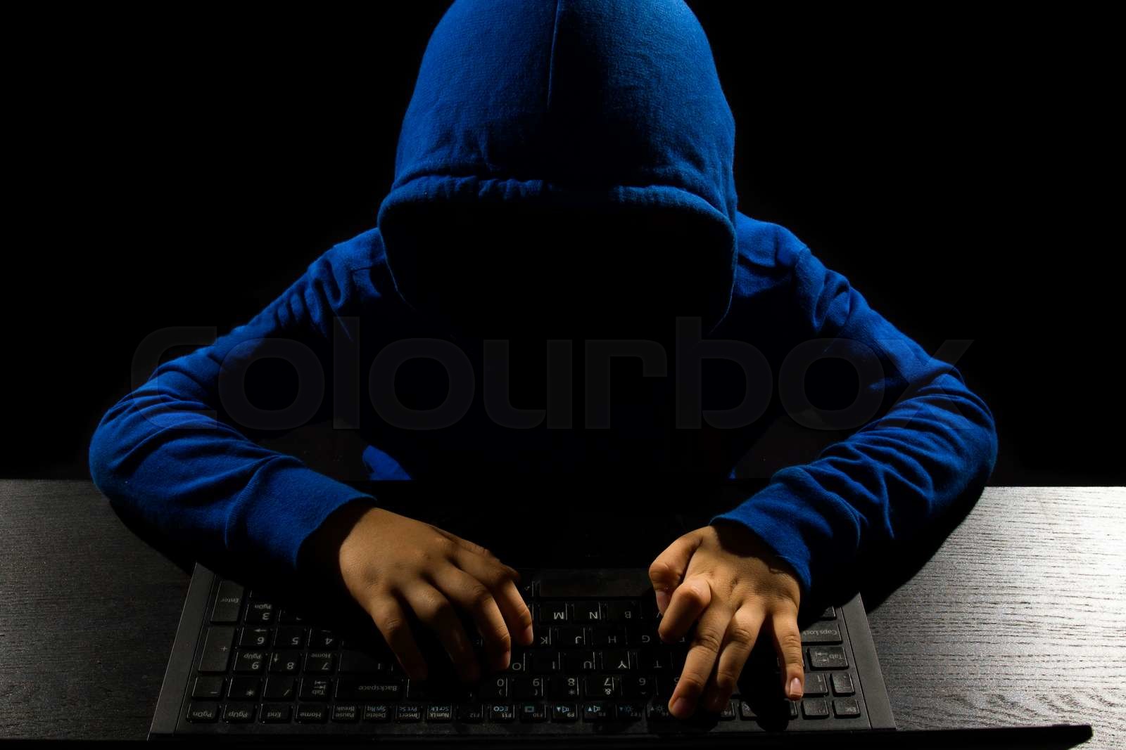 Faceless Hacker using computer | Stock image | Colourbox