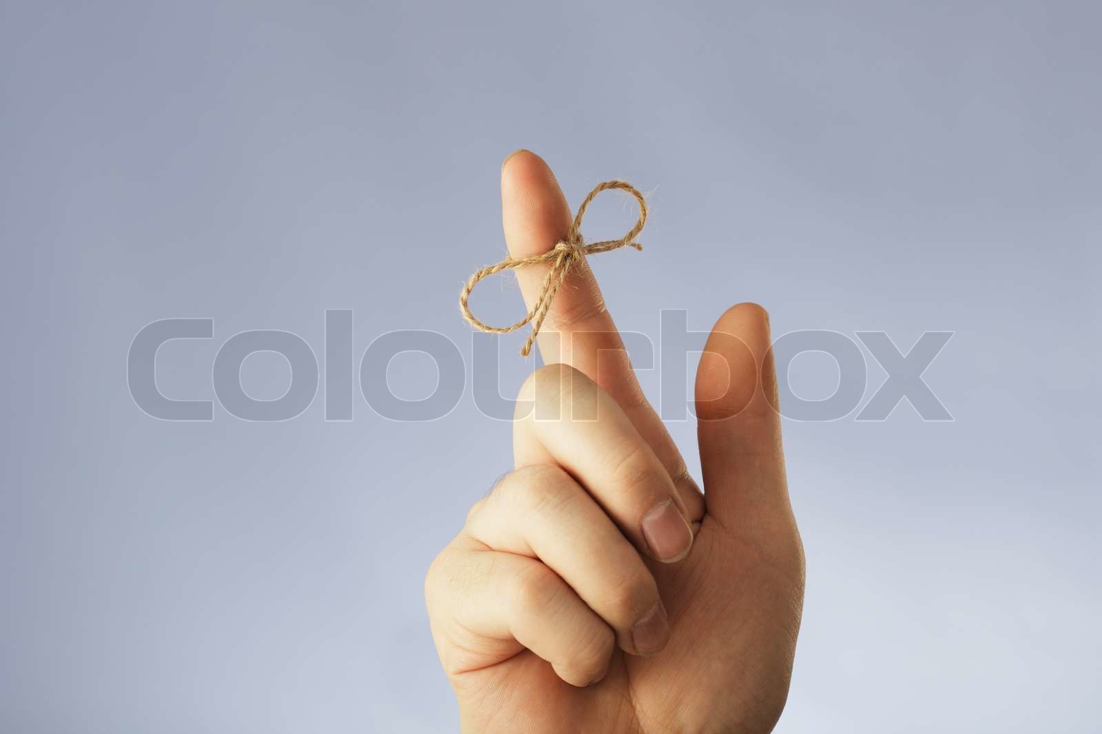 A string tied around an index finger | Stock image | Colourbox
