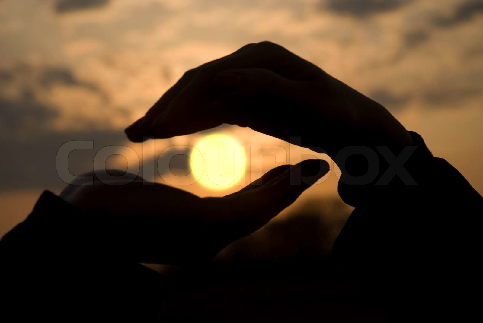 two hands holding the sun | Stock image | Colourbox