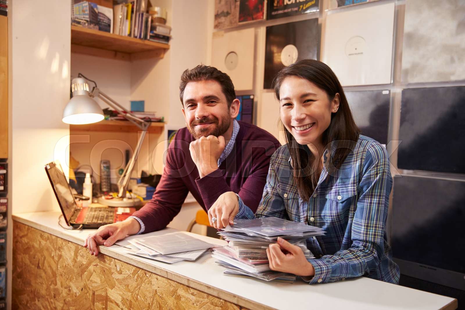 Man and woman working behind the counter at a record shop | Stock image ...