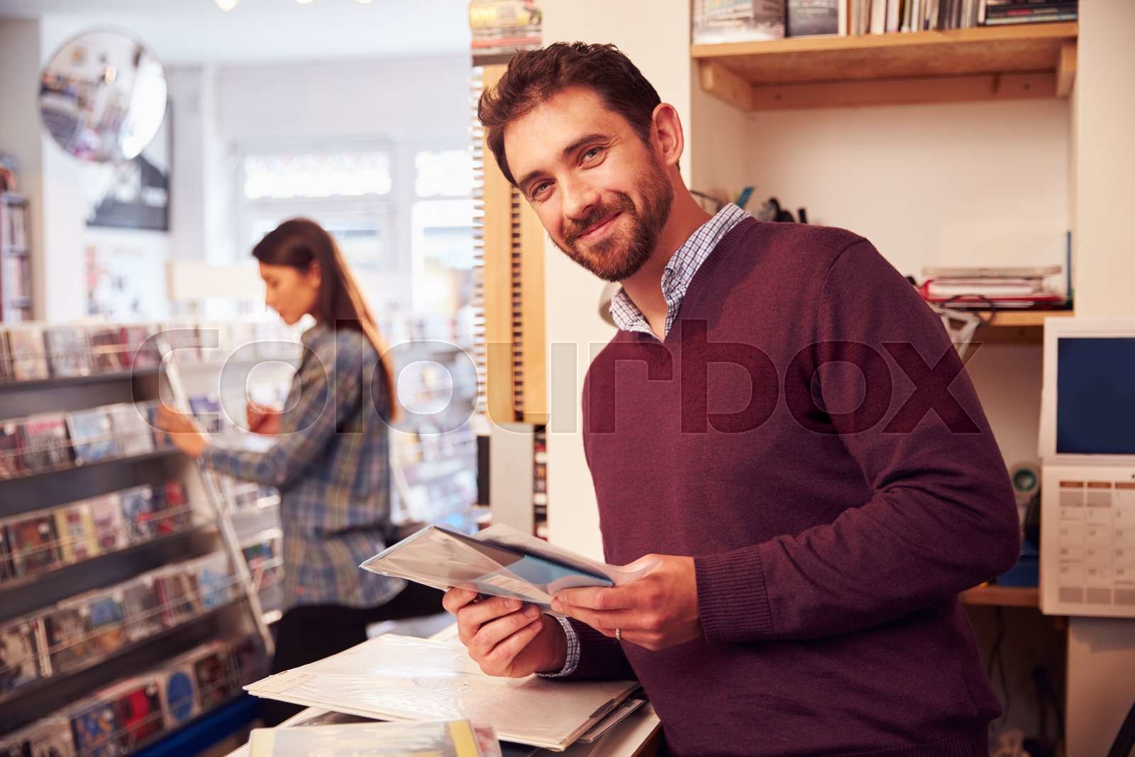 Man working behind the counter at a record shop, portrait | Stock image ...