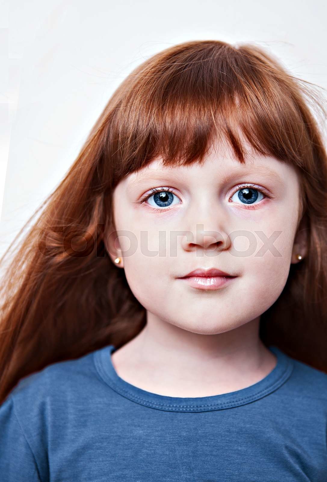 Close up portrait of little ginger girl posing in studio | Stock image ...