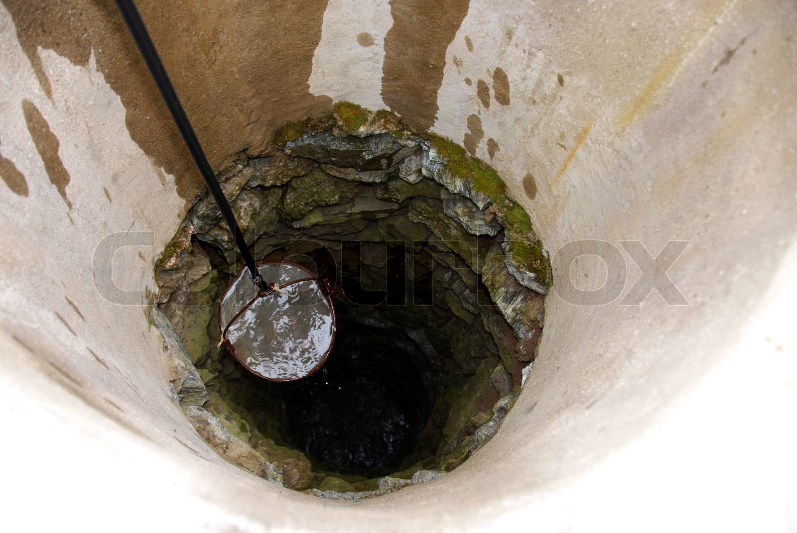 pulling out bucket full of drink water from deep well | Stock image ...