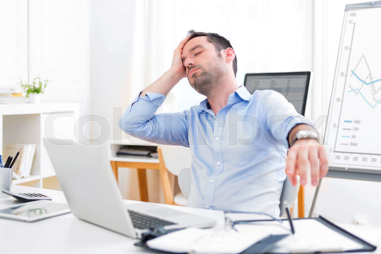 Young attractive man too tired to work | Stock image | Colourbox