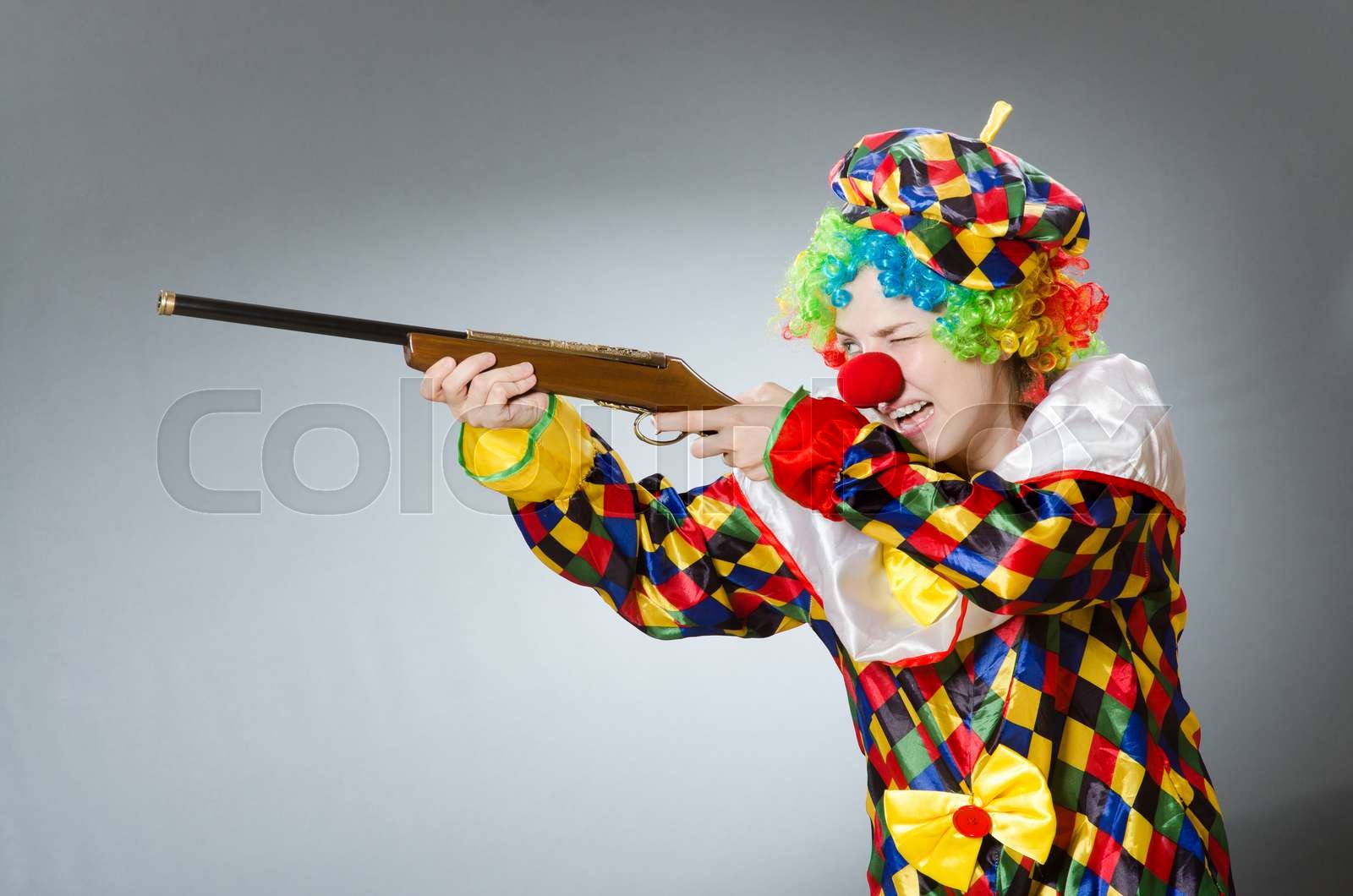 Clown with rifle isolated on white | Stock image | Colourbox