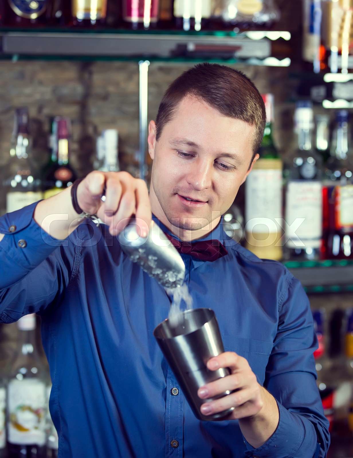 young man working as a bartender in a nightclub bar | Stock image ...