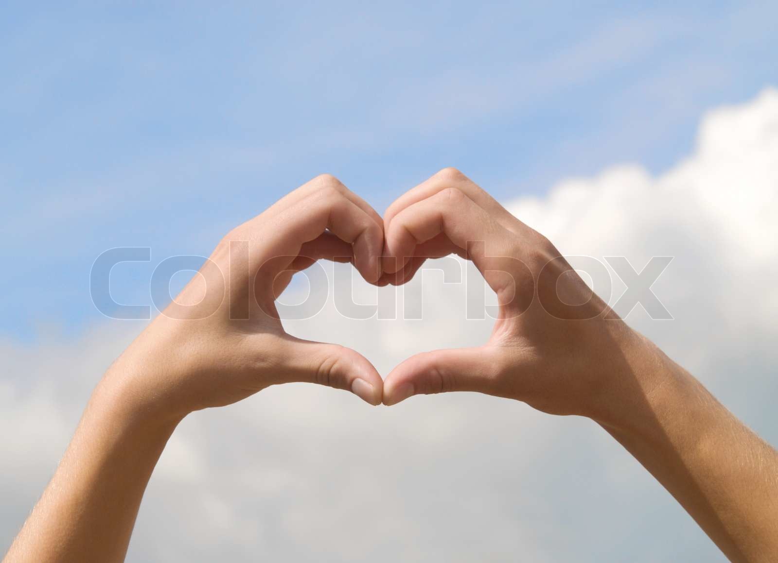 hænder i form af hjerte på blå himmel baggrund | Stock foto | Colourbox