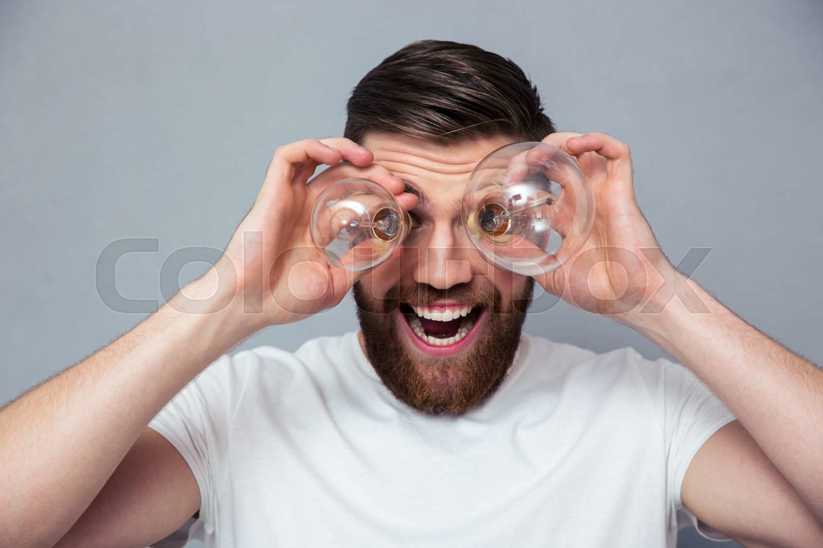 Funny man looking at camera through bulb | Stock image | Colourbox