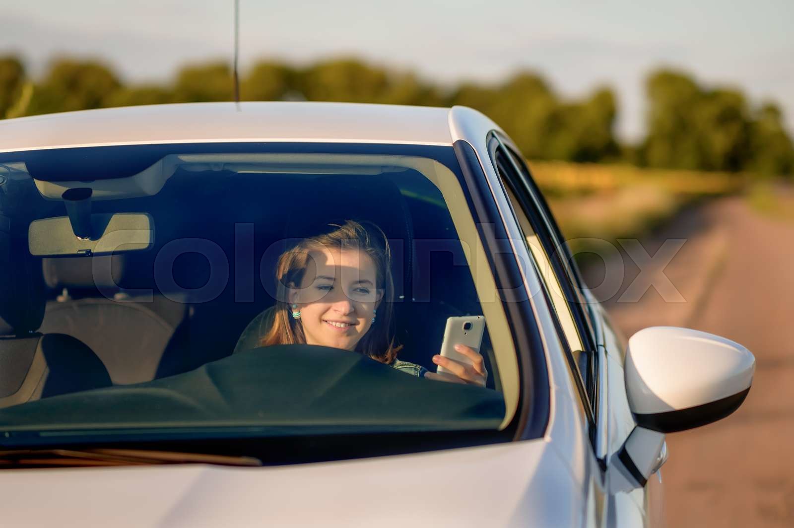 Teenage Girl Texting While Driving White Car | Stock image | Colourbox