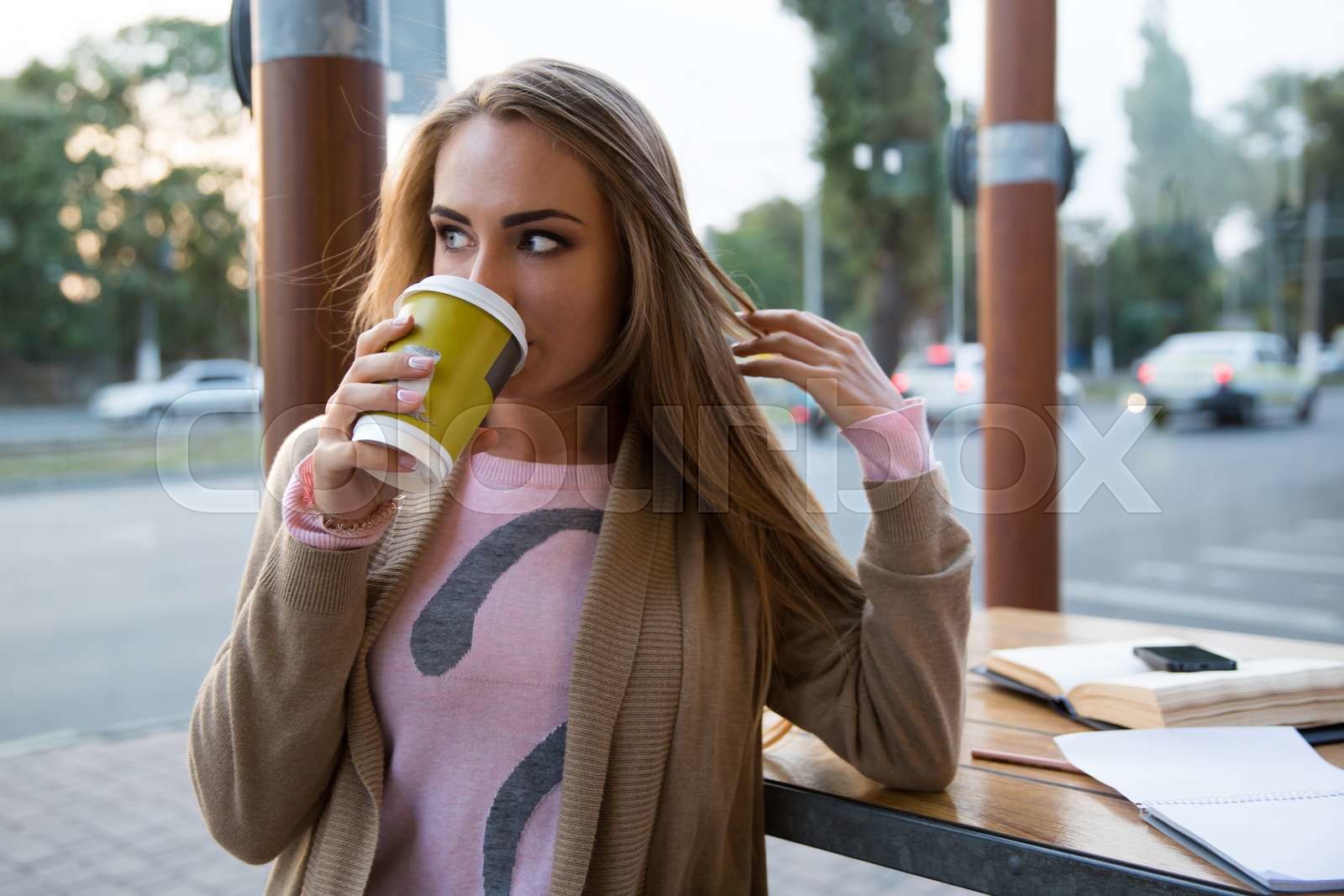 Girl drinking coffee in cafe | Stock image | Colourbox