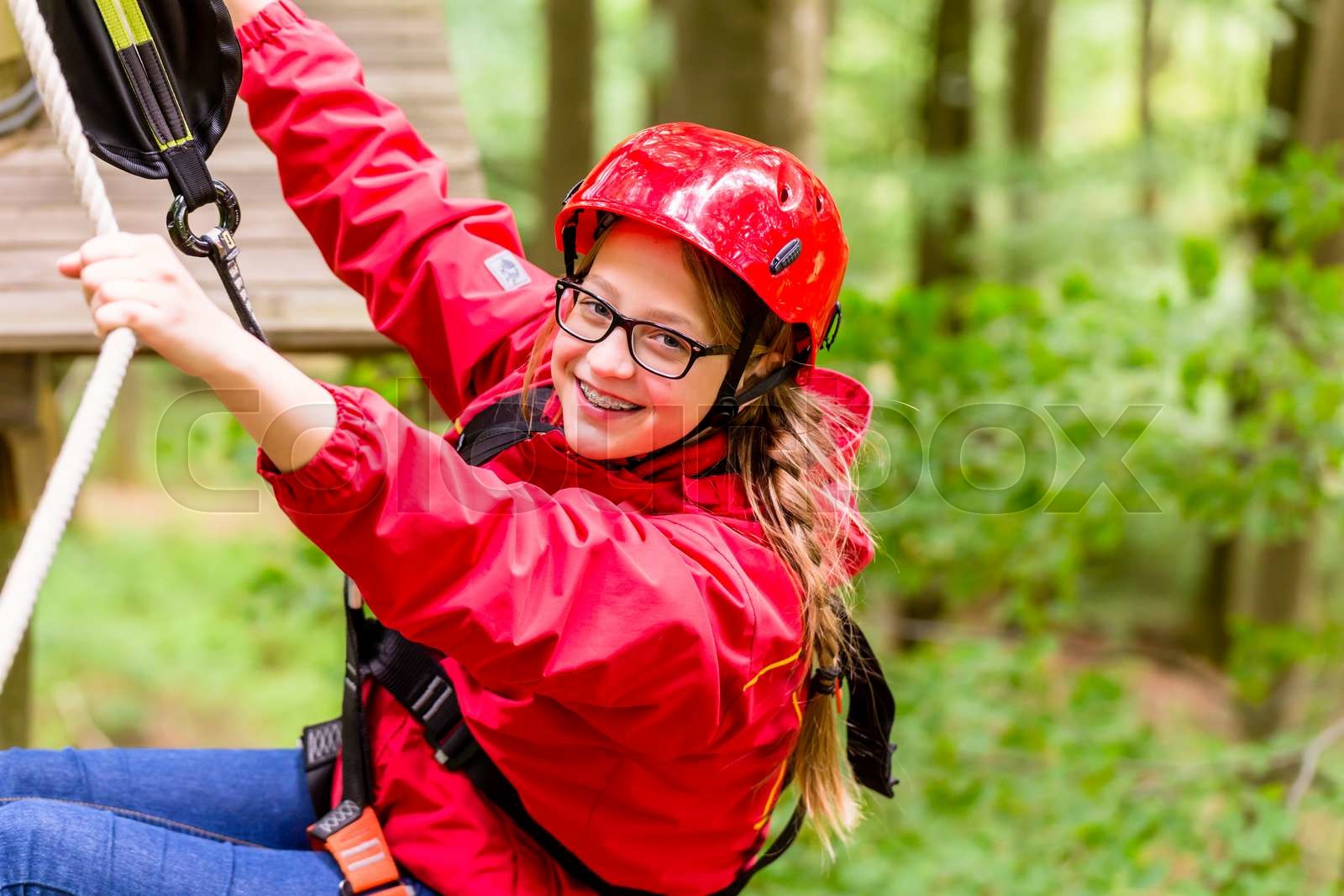 Child reaching platform climbing in high rope course | Stock image ...