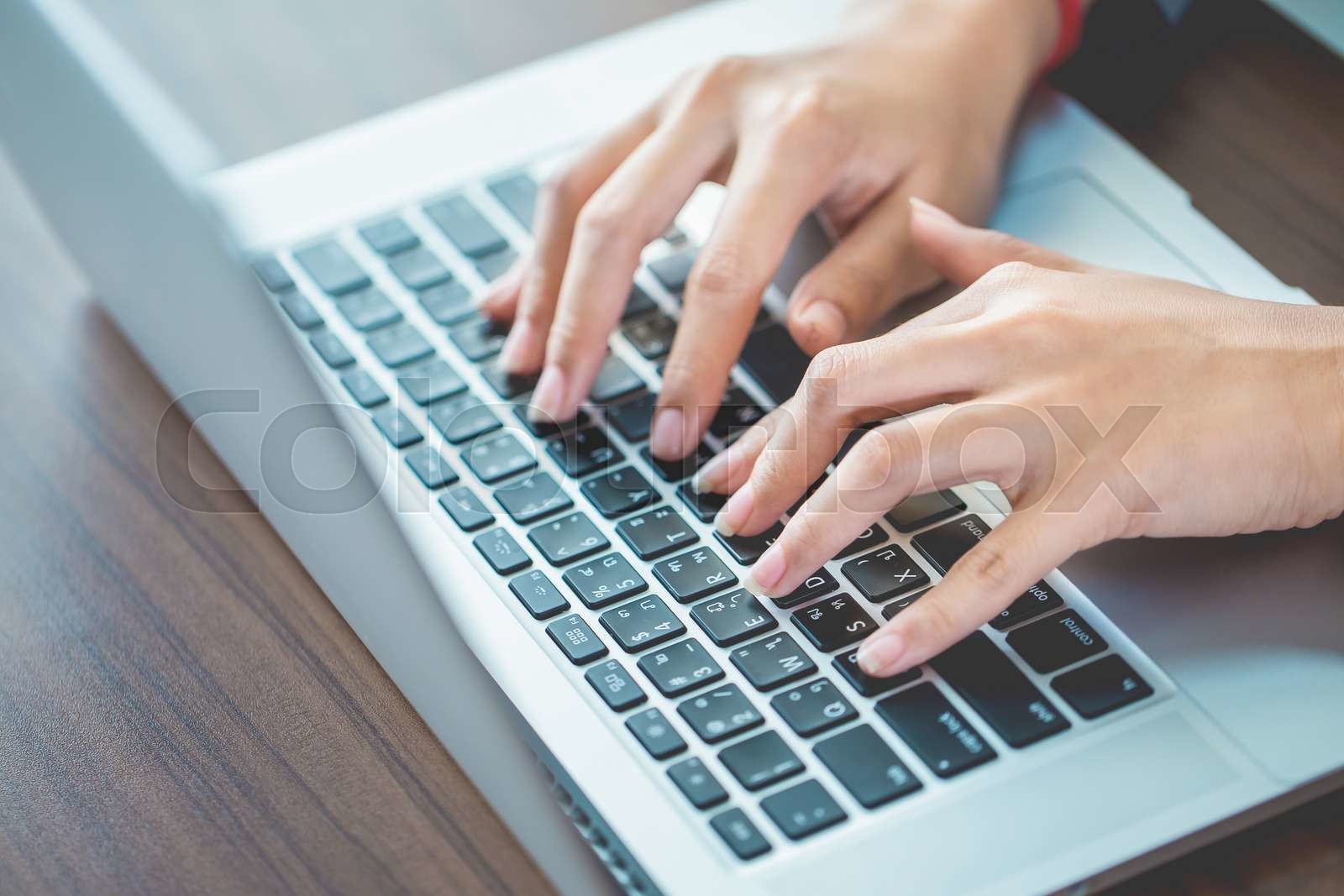 Female office worker typing on the keyboard | Stock image | Colourbox