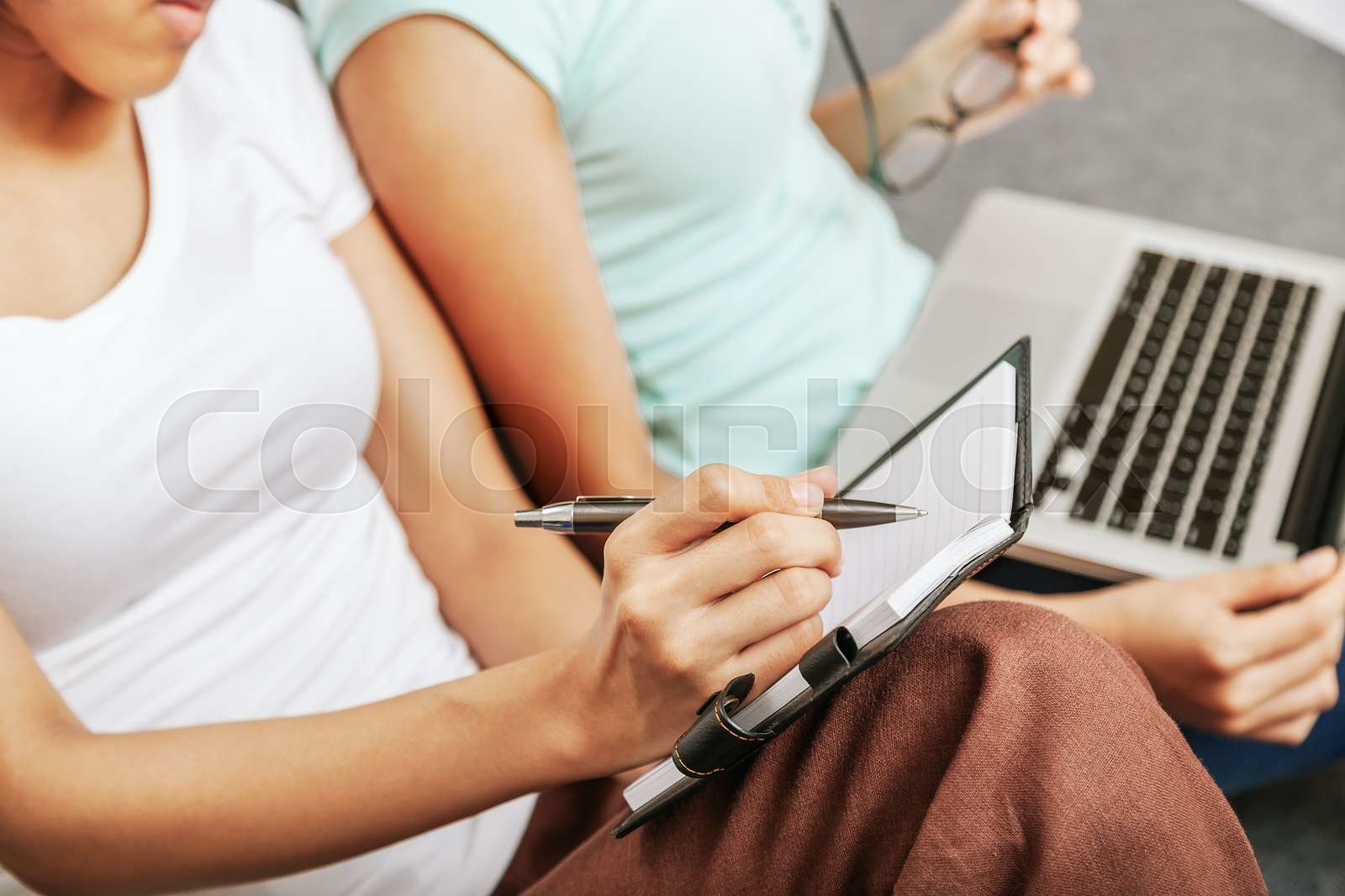 student writing note on her book | Stock image | Colourbox