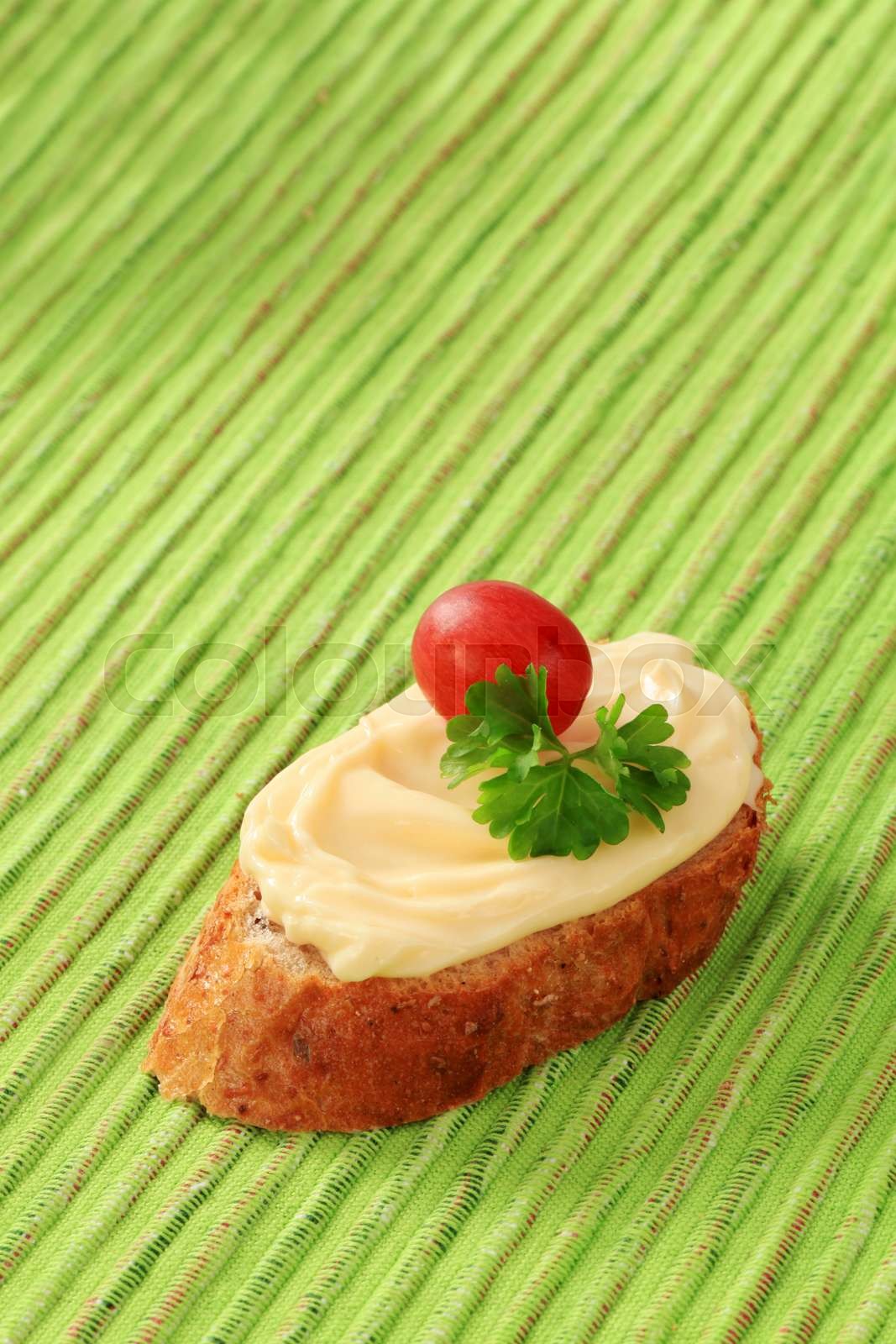 Slice of bread roll and creamy cheese spread | Stock image | Colourbox