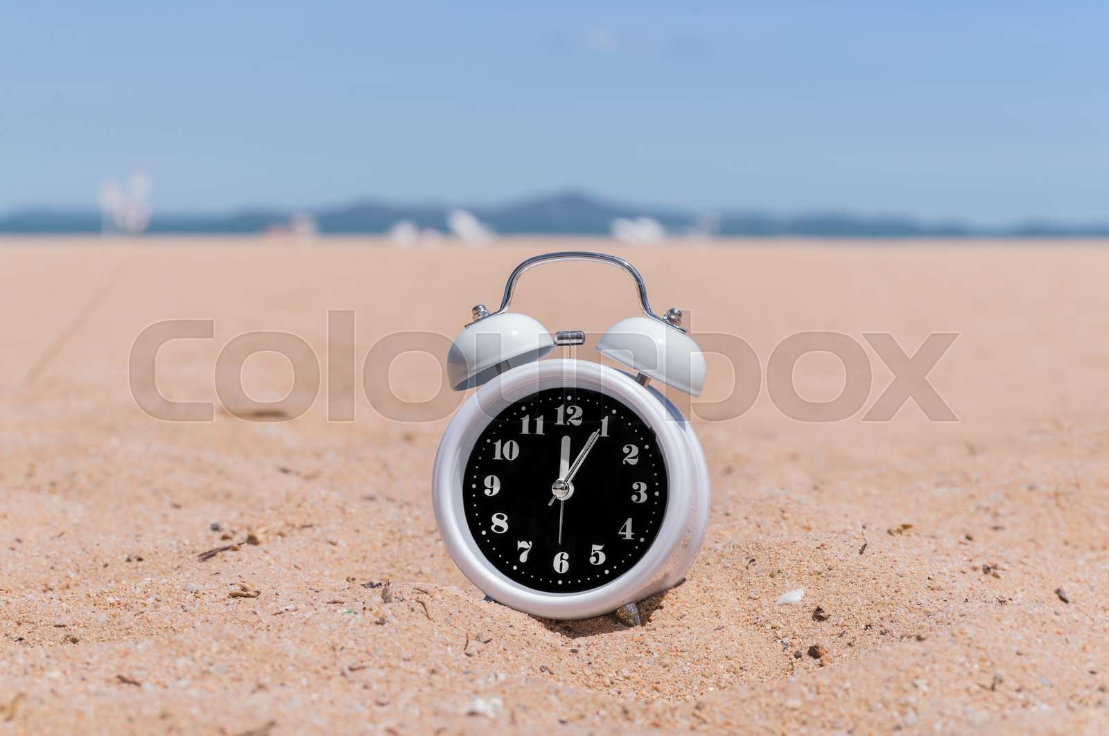 Classic analog clocks in sand on the beach | Stock image | Colourbox
