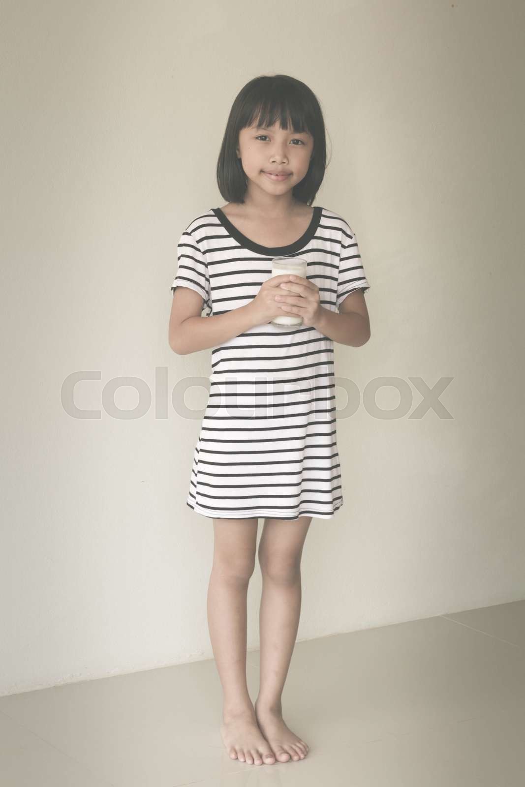 Gorgeous little girl wearing striped encouraged to drink milk - Vintage ...