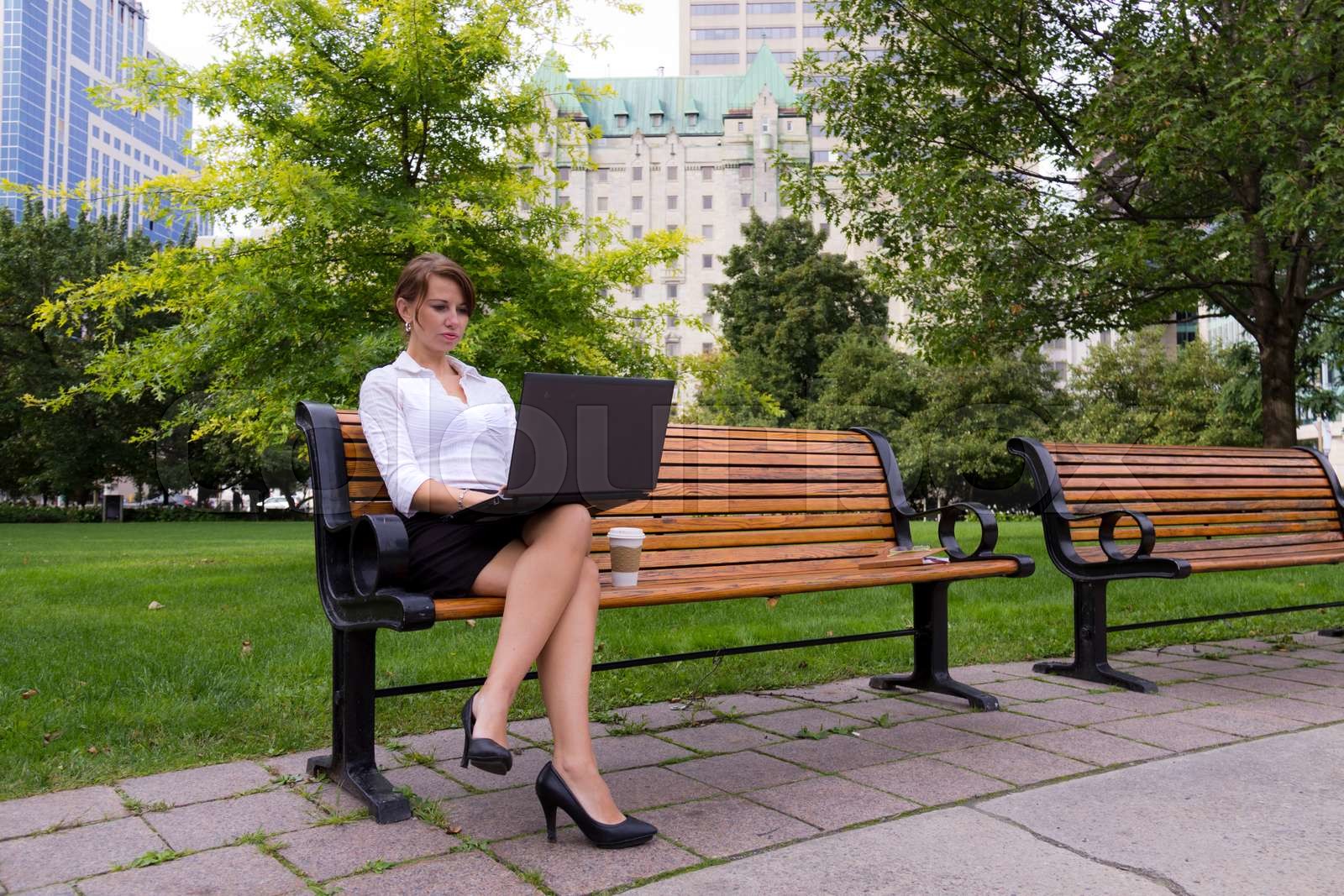 Business woman on park bench working with laptop computer | Stock image ...