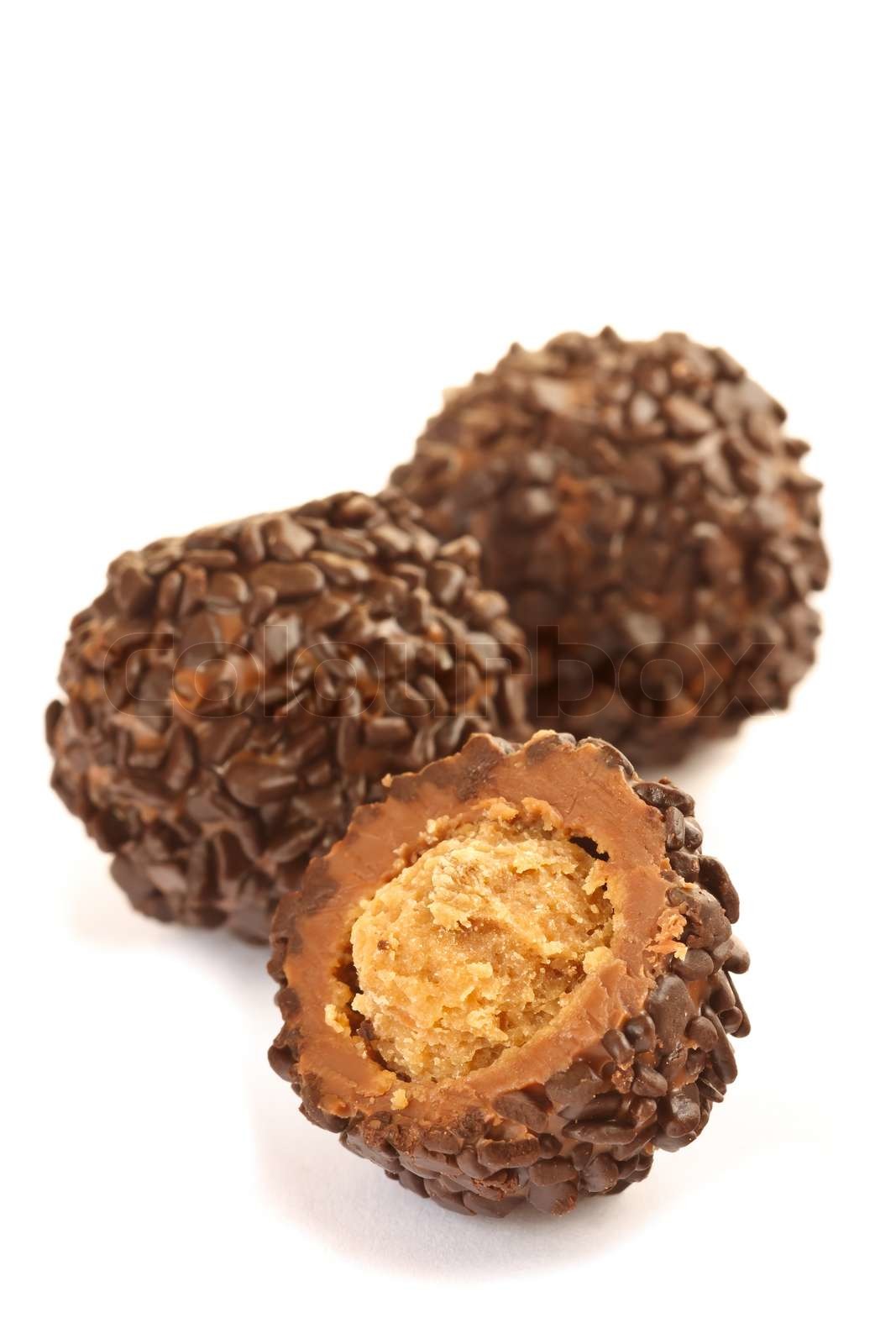 Chocolate balls and a half with praline filling isolated on white ...