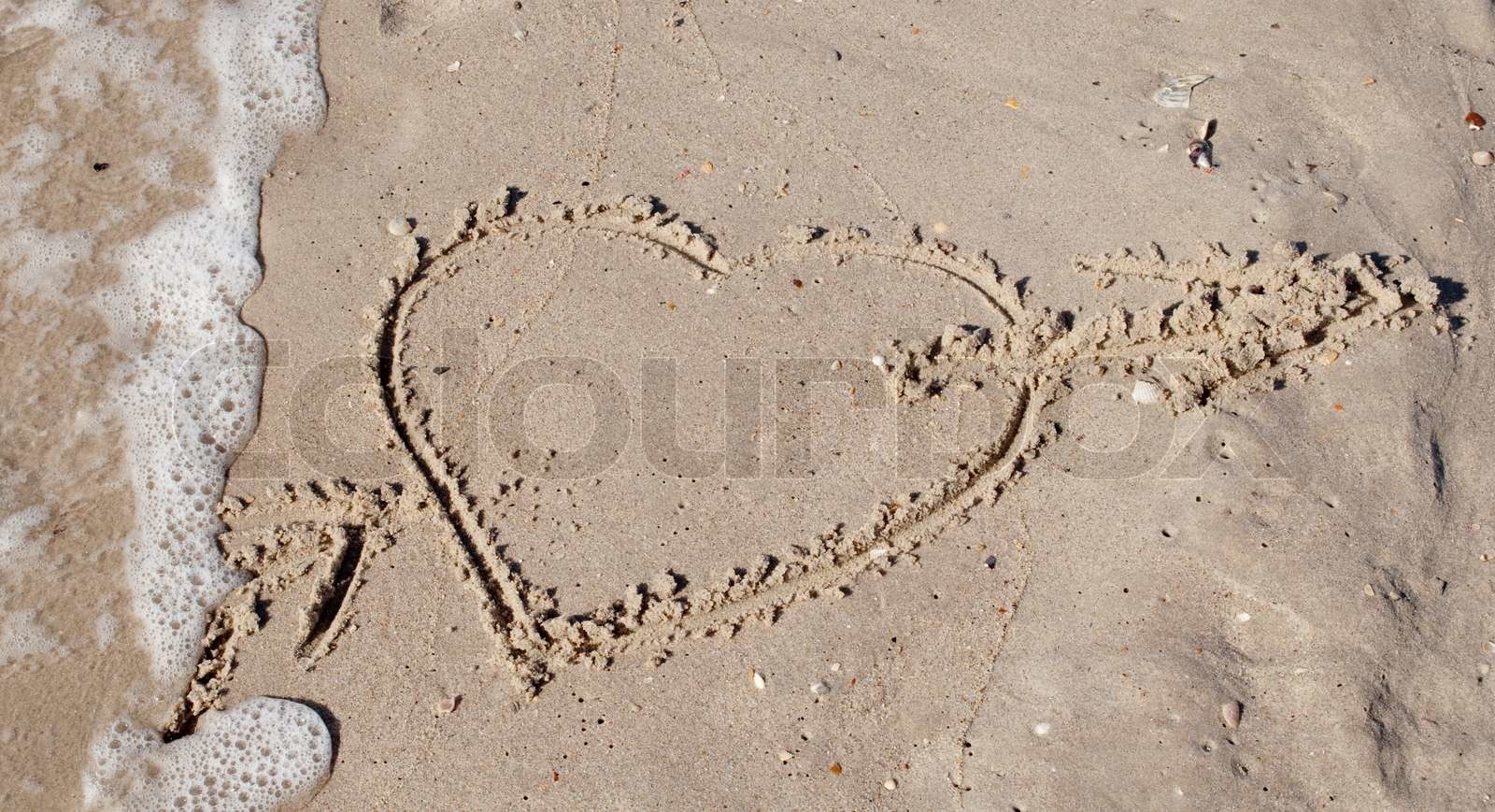 Amor hjerte med en pil i sandet | Stock foto | Colourbox