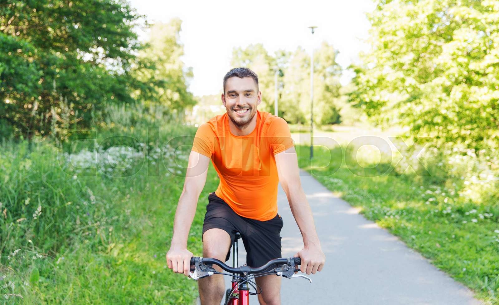 happy young man riding bicycle outdoors | Stock image | Colourbox