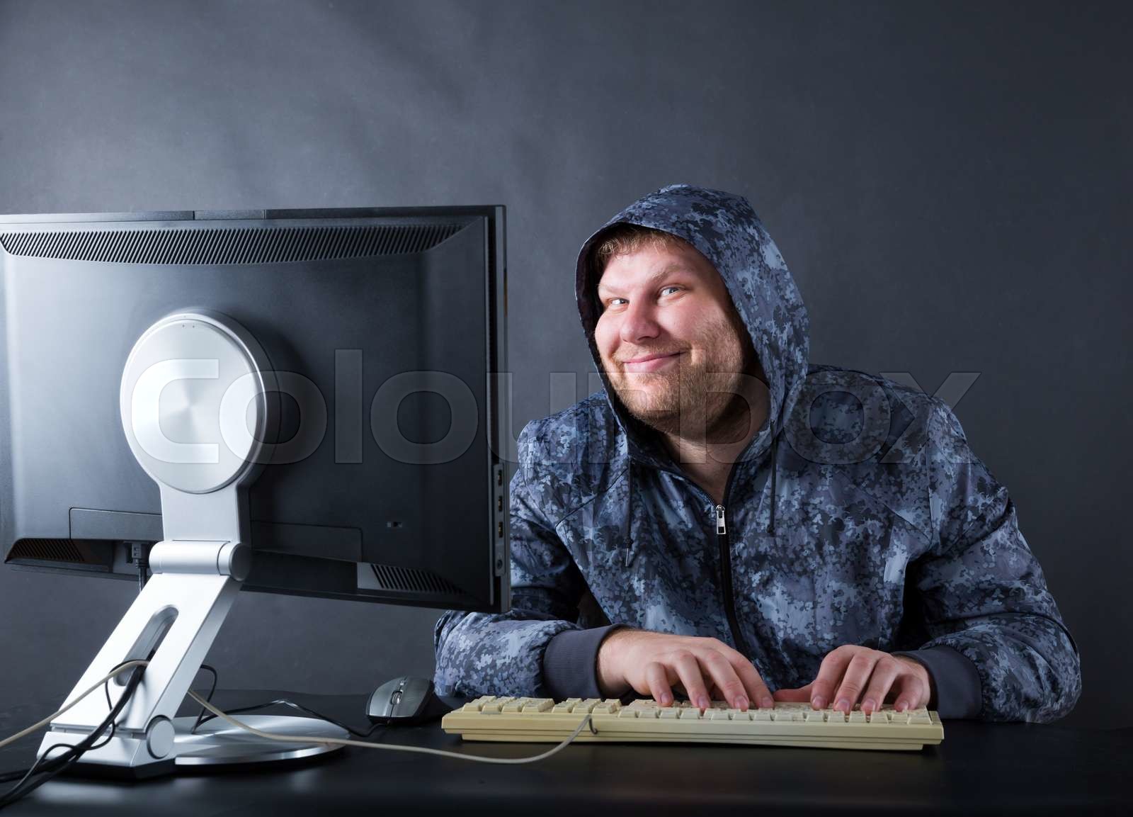 Man sitting at desk looking on computer screen | Stock image | Colourbox