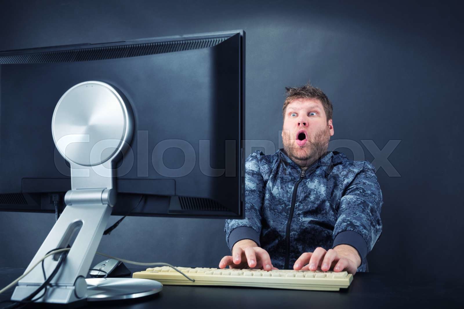 Man sitting at desk looking on computer screen | Stock image | Colourbox