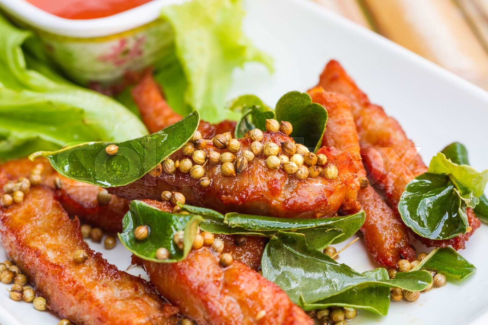 Deep fried pork with leech lime leaf and chili sauce | Stock image ...