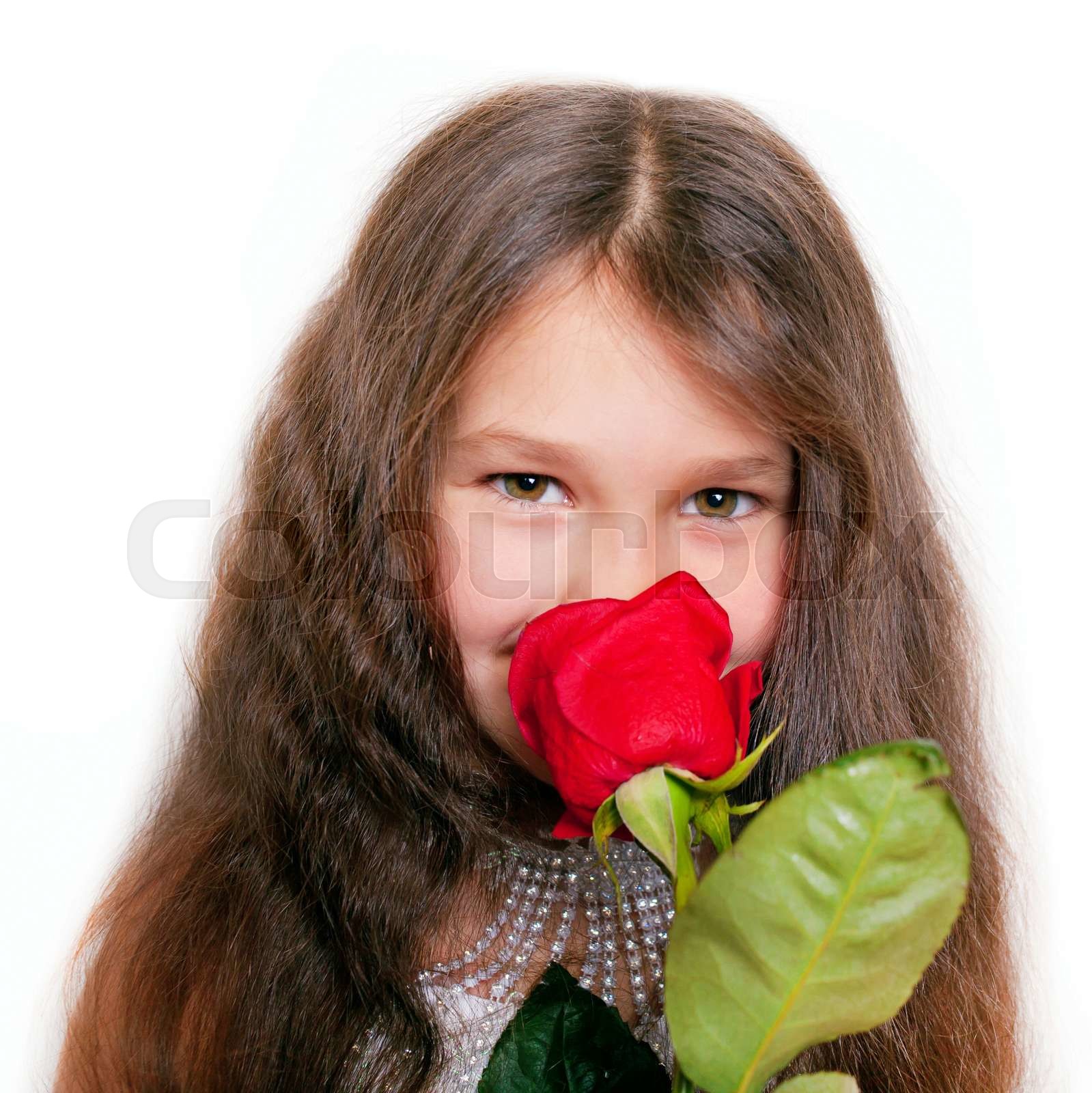 Little girl smelling a red rose. | Stock image | Colourbox