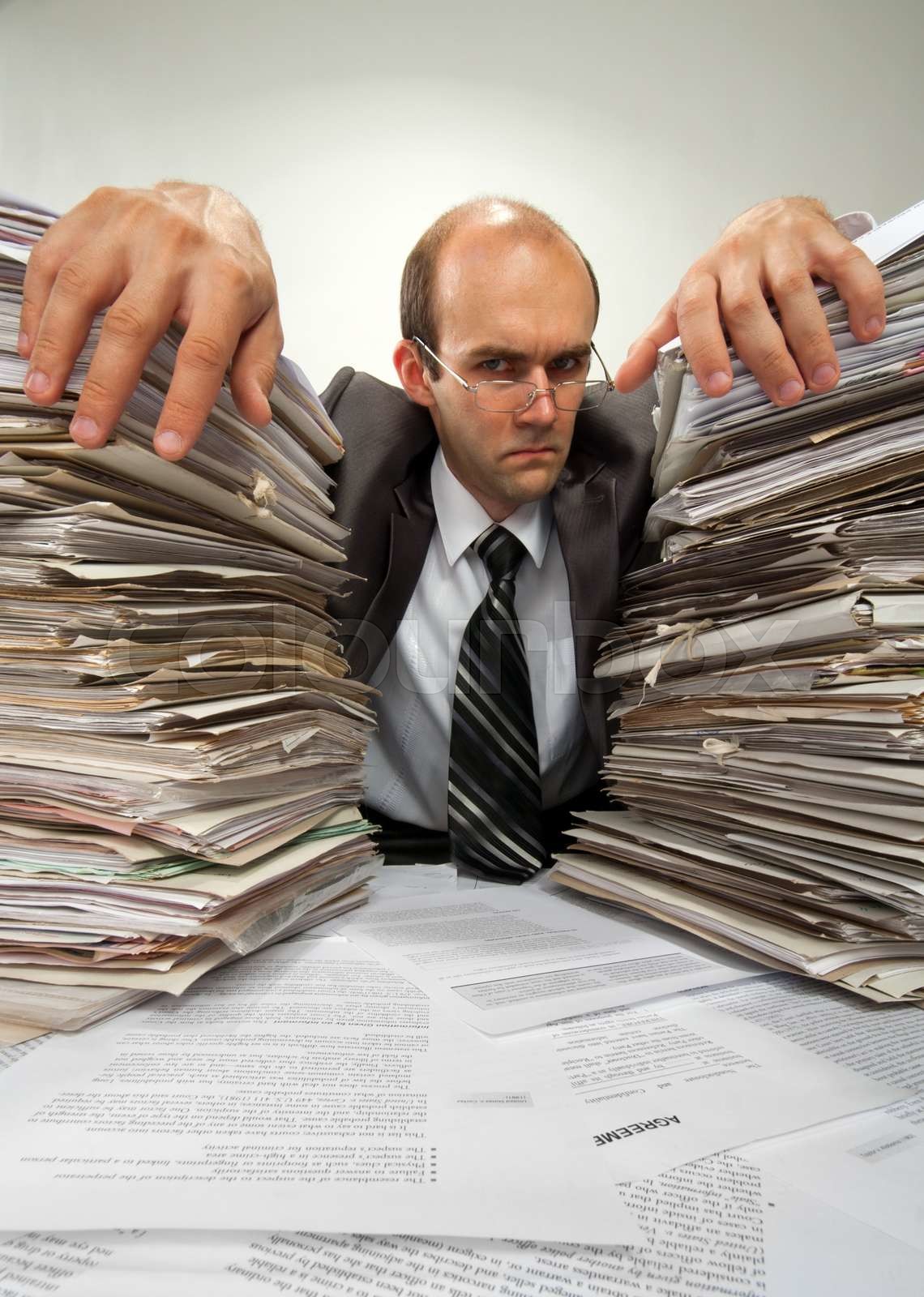 Businessman with big piles of paperwork | Stock image | Colourbox
