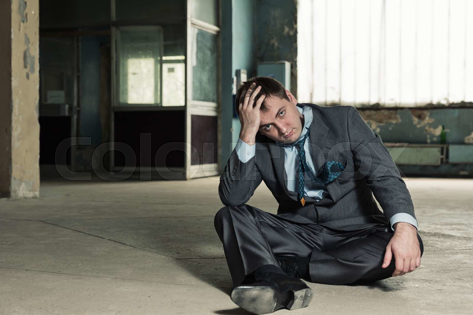 Poor businessman sitting on old cellar | Stock image | Colourbox
