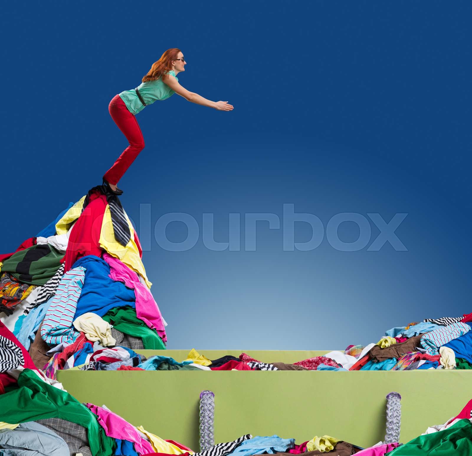 Woman flying to the heap of clothes | Stock image | Colourbox