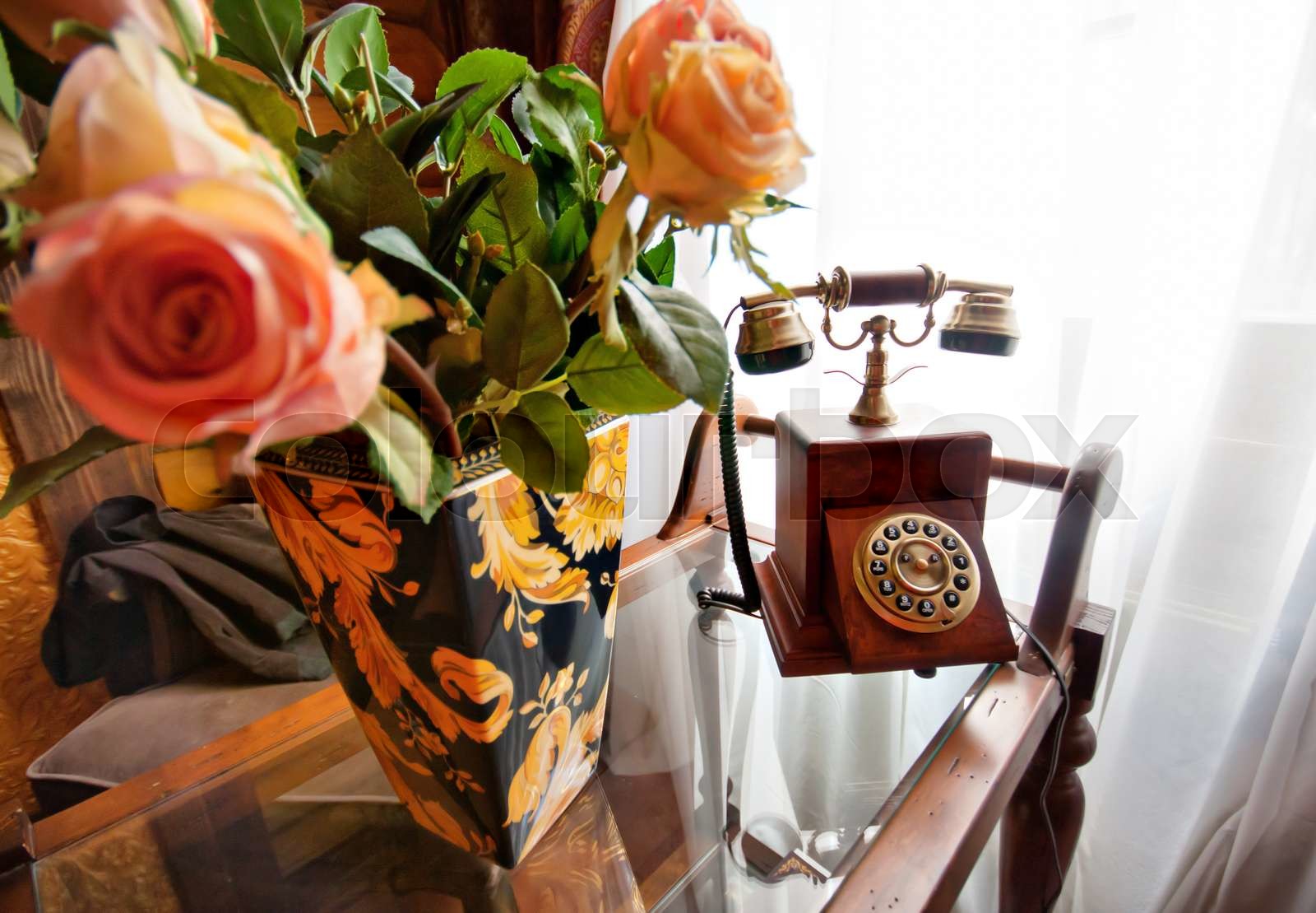Retro wood telephone and vase full of roses | Stock image | Colourbox