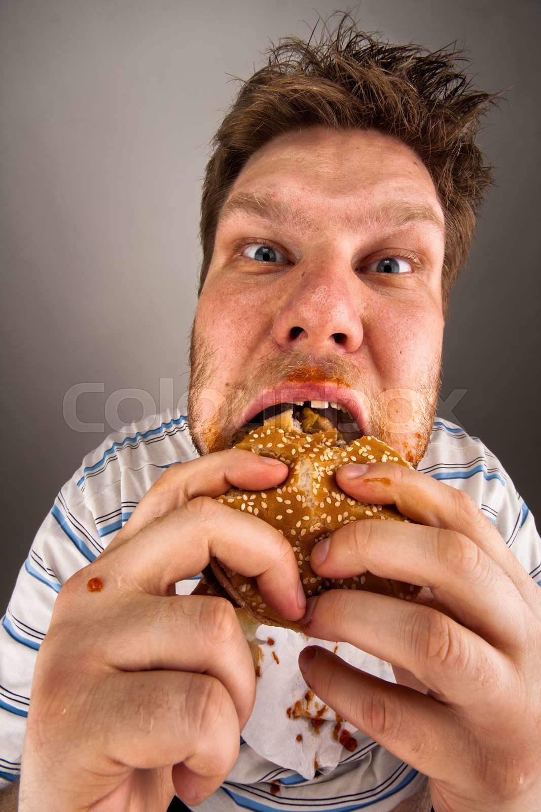 Man chewing hamburger | Stock image | Colourbox