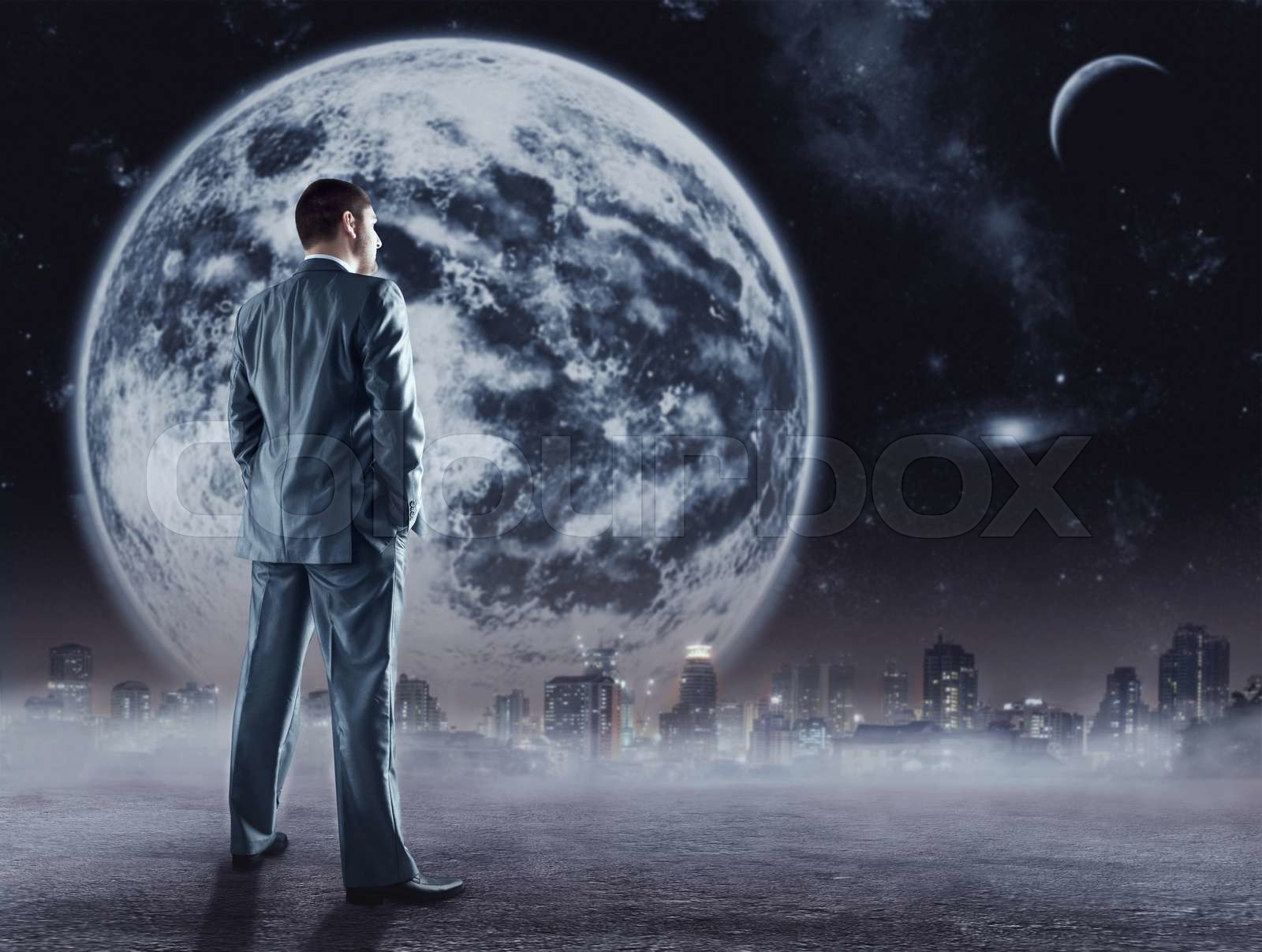Businessman stands looking at the moon | Stock image | Colourbox