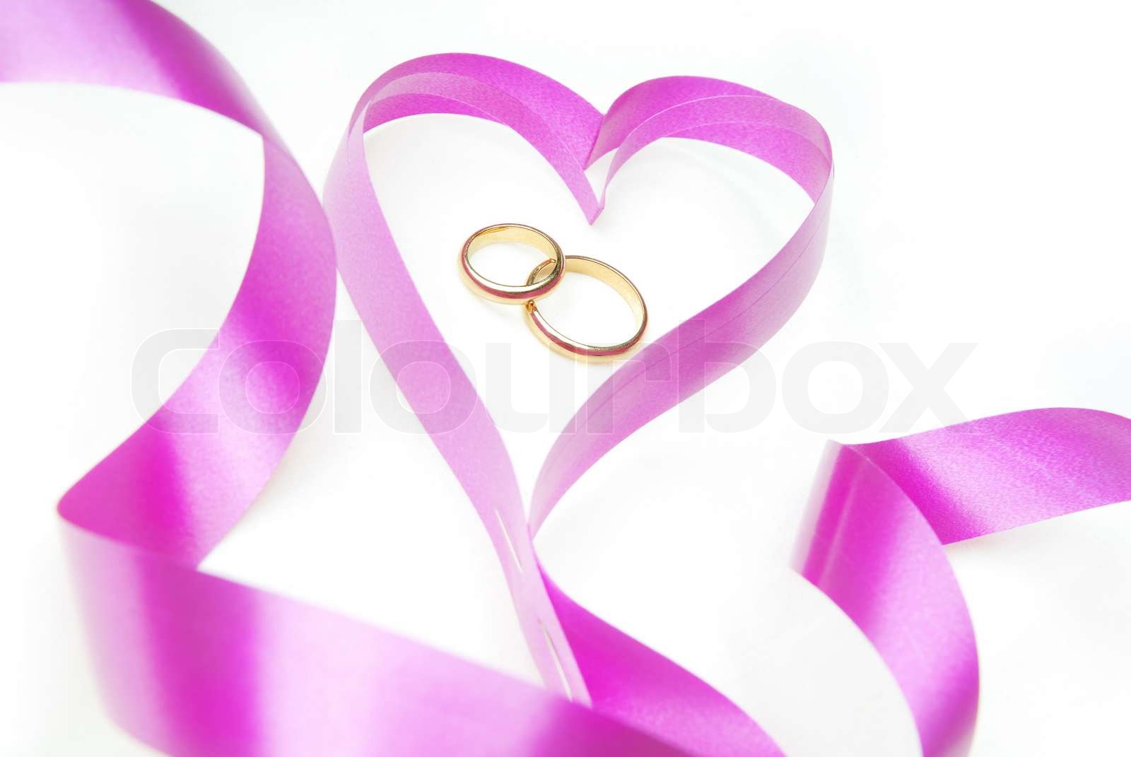 Wedding rings in the purple ribbon in the shape of heart | Stock image ...