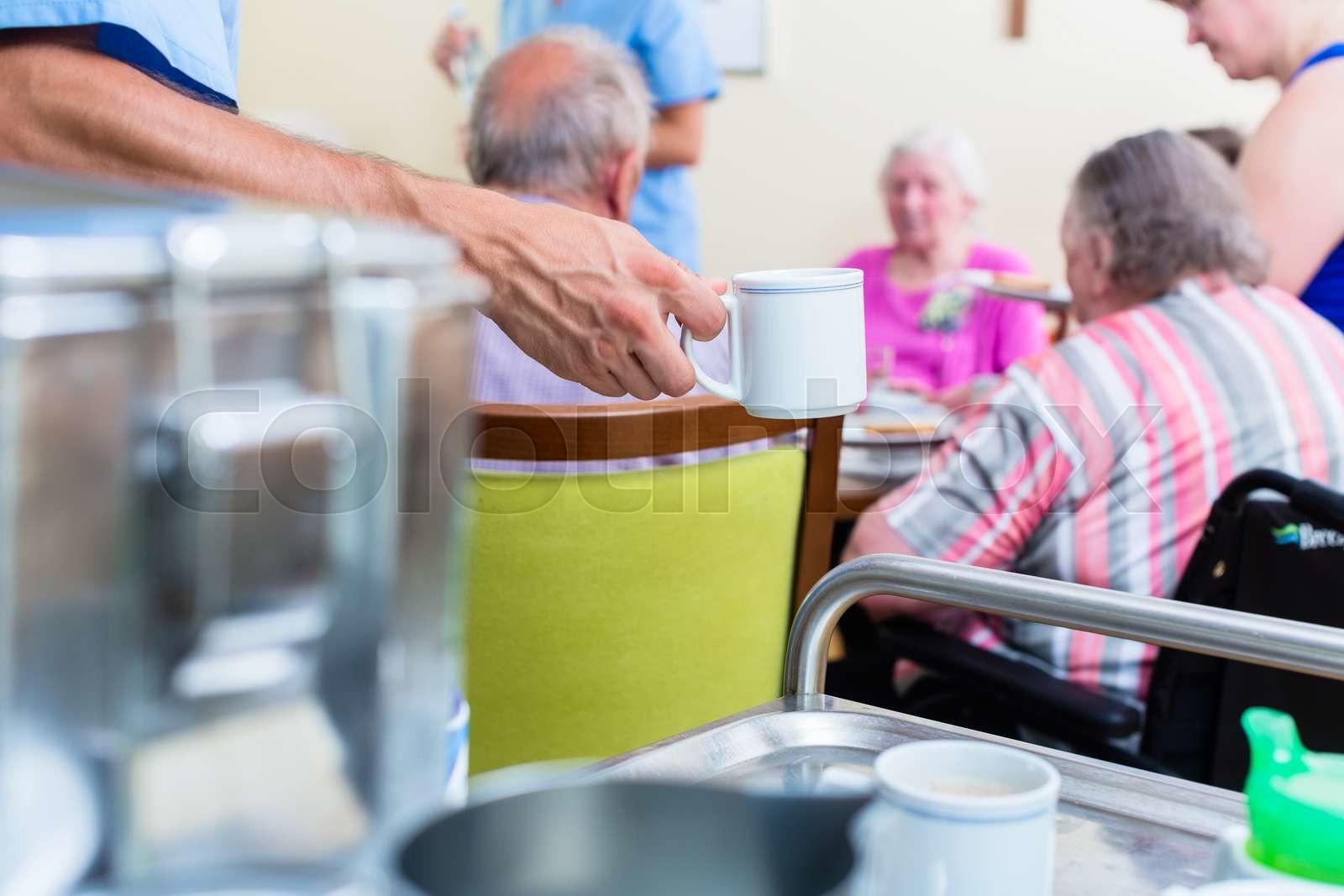 Nurse serving food in nursing home | Stock image | Colourbox
