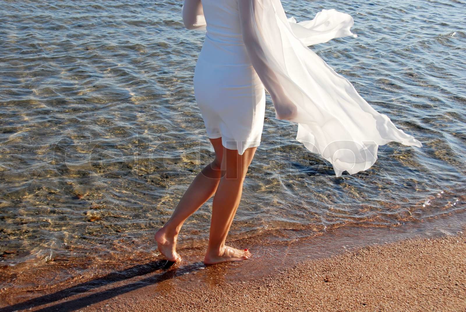 Kvinde I Hvid Kjole Går På Stranden Stock Foto Colourbox