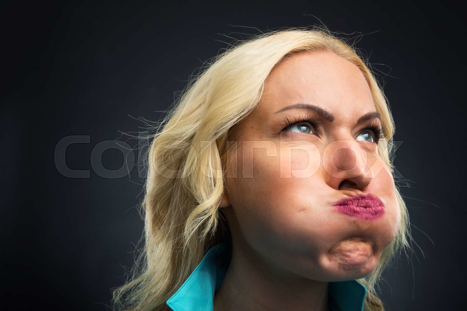 Woman blowing out her cheeks | Stock image | Colourbox