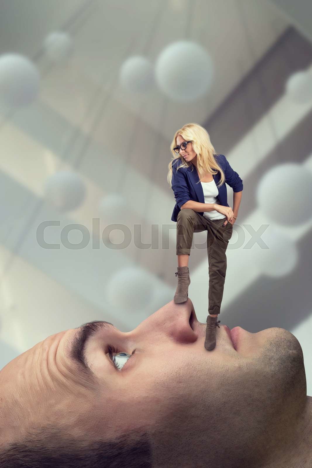Woman standing on male face | Stock image | Colourbox