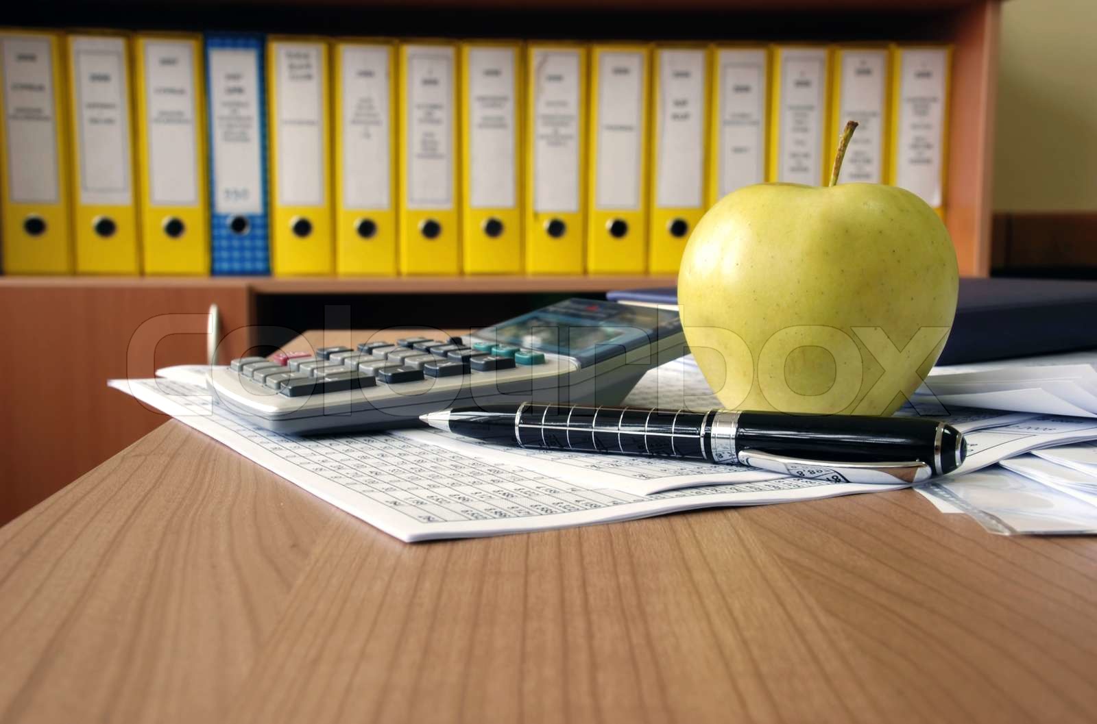 office desk papers, calculator, pen and apple | Stock image | Colourbox