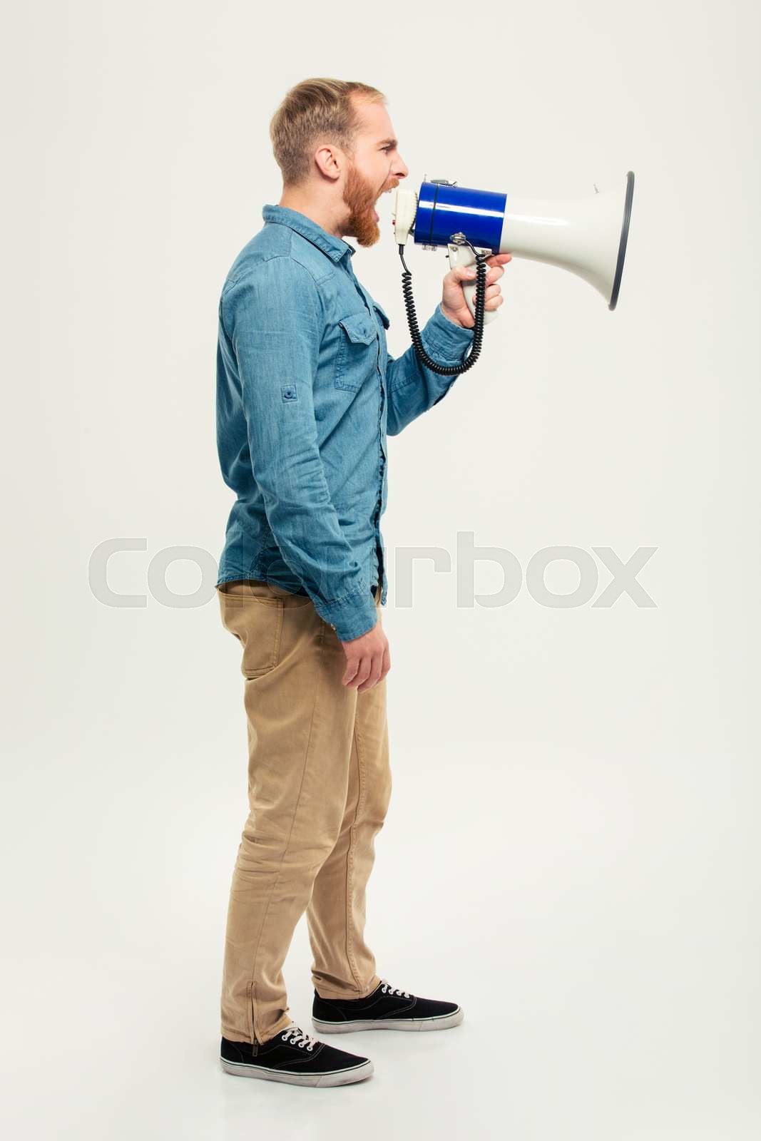 Side view portrait of a casual man screaming in megaphone | Stock image ...
