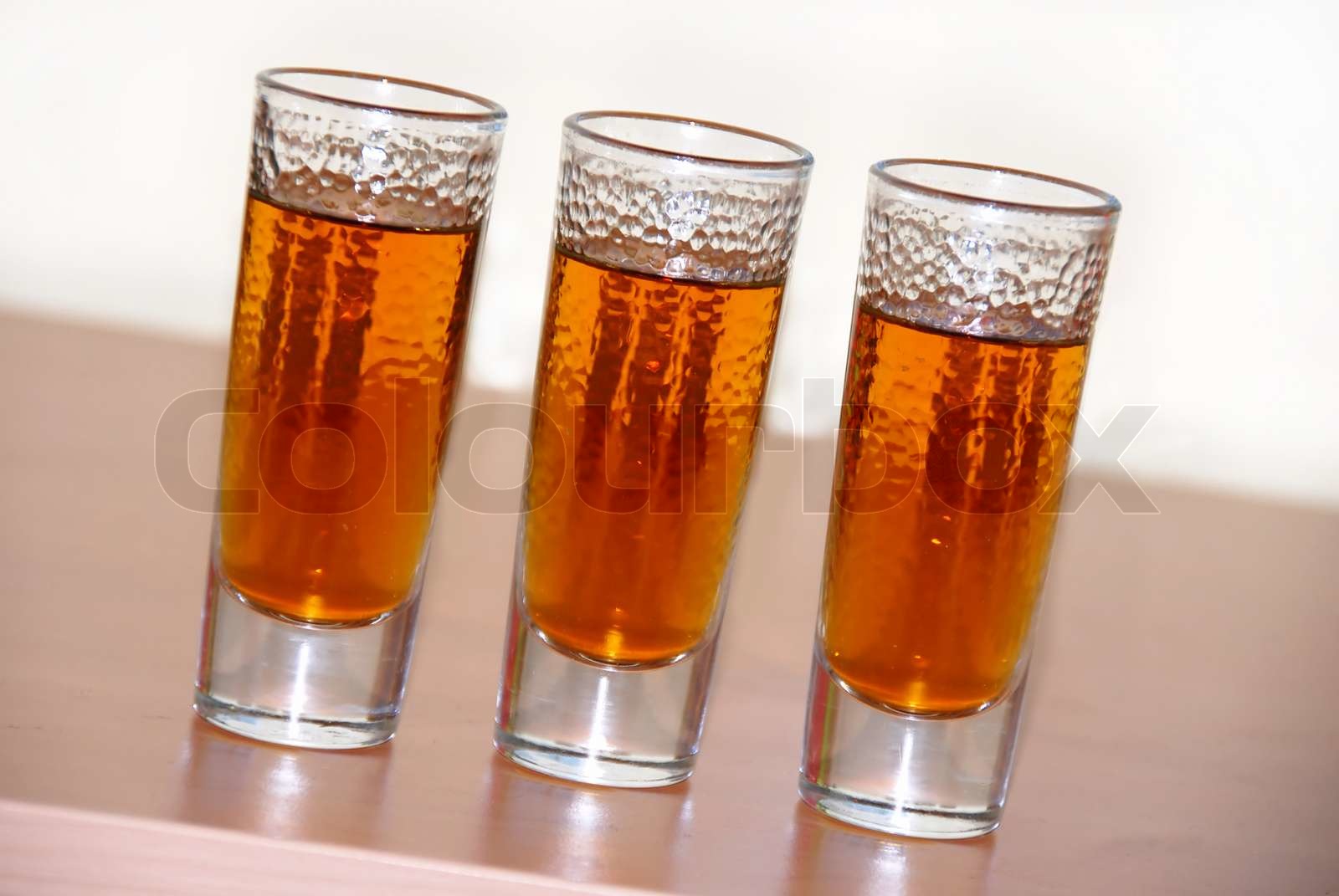 three small glasses of brown alcohol drink closeup | Stock image ...