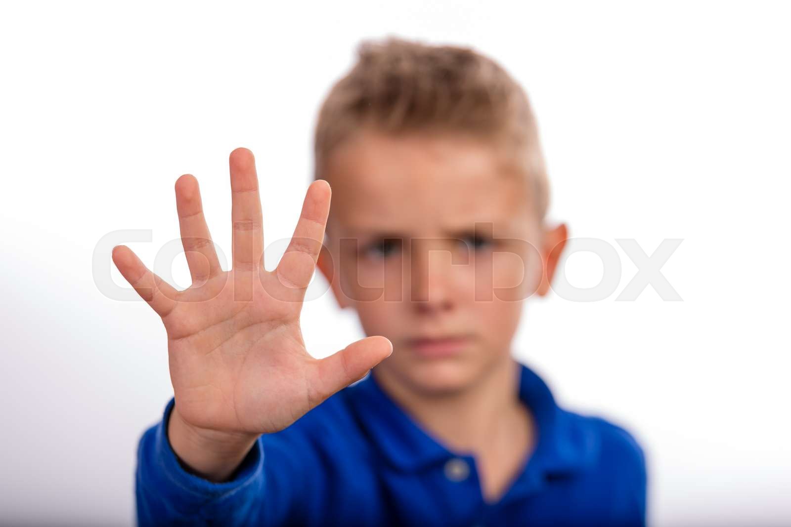 Boy with raised hand making stop gesture | Stock image | Colourbox