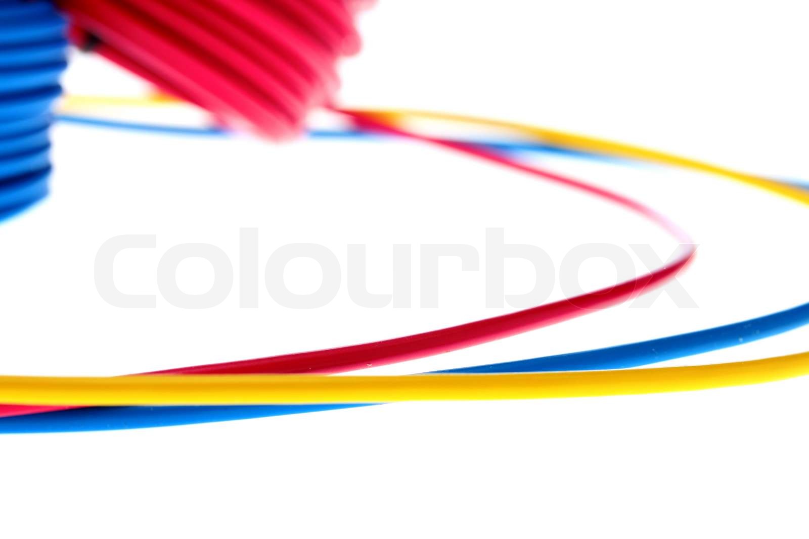 Electric wires of red, yellow and dark blue colour are winded in rings ...