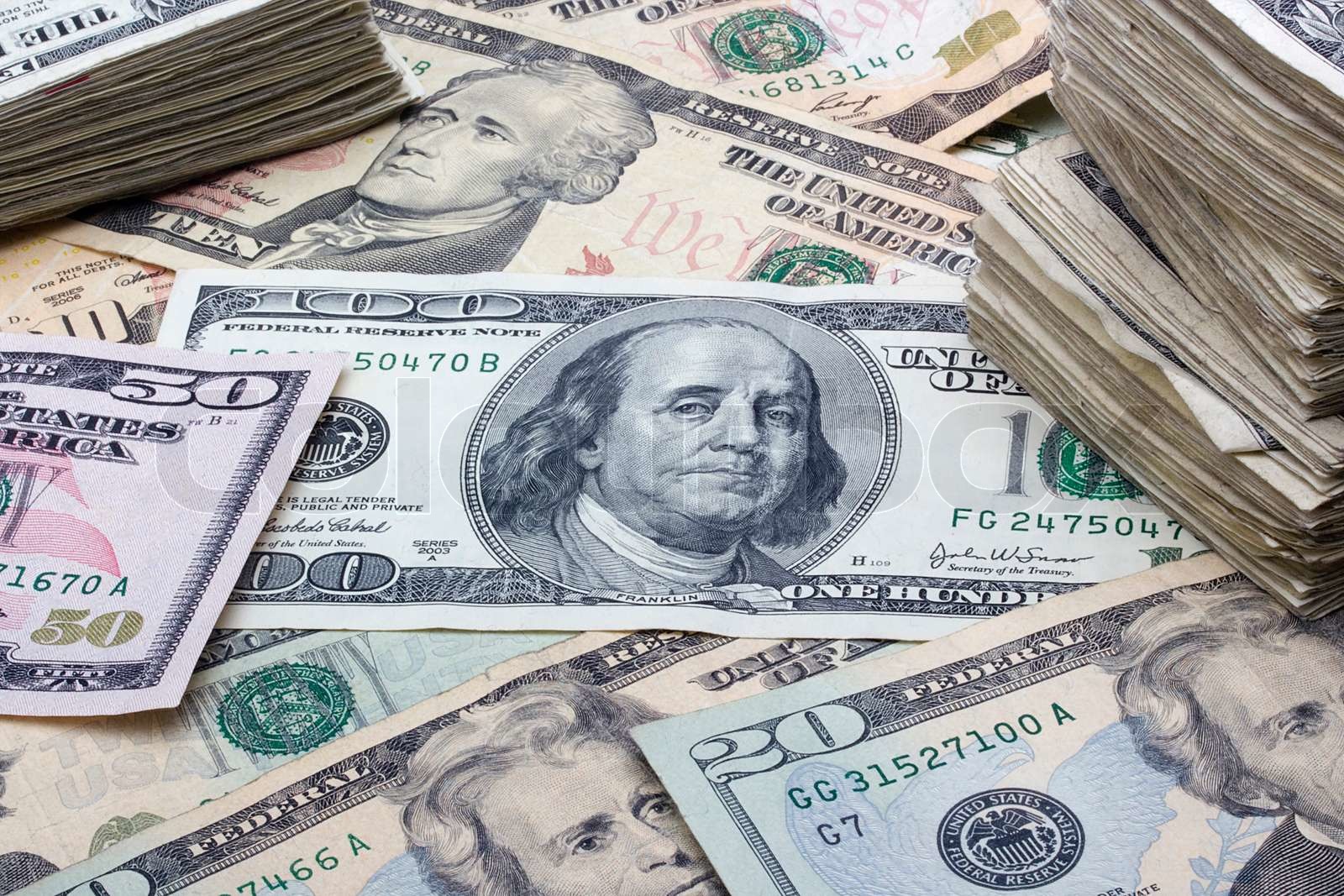 Variety of American money laid out under a stack of cash. | Stock image ...