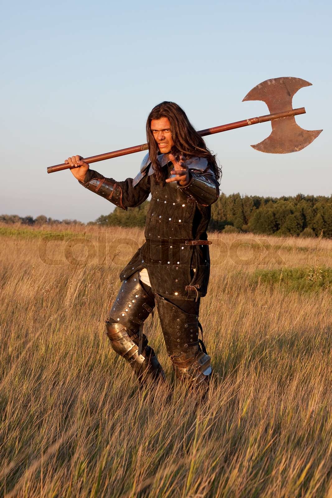 Medieval knight in the field with an axe | Stock image | Colourbox